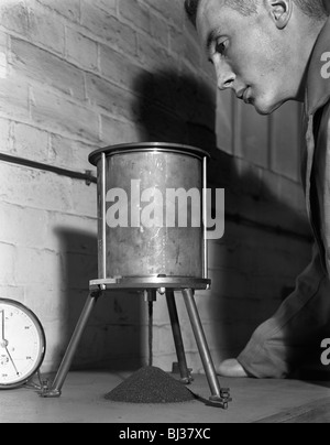 A lab technician undertaking a coal flow test, Mapperley Colliery ...