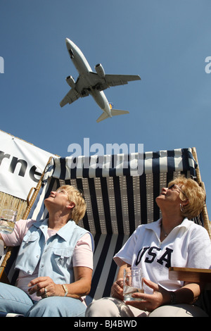 People watch an airplane flying over at Baunia, a place at the end of ...