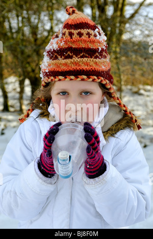 Volumatic asthma inhaler. A girl with asthma uses an aerosol inhaler ...