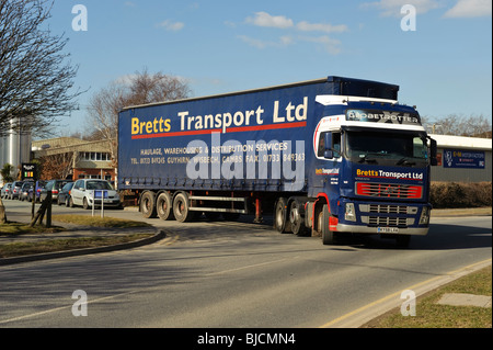 HGV lorry transport truck & articulated flat bed trailer driving along ...
