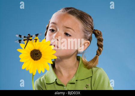Child looking at a flower and a dragonfly Stock Photo - Alamy