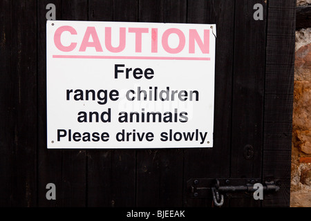 A caution free range children and animals, please drive slowly sign ...