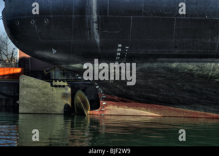 View of ship propeller and rudder in a dry dock background ...