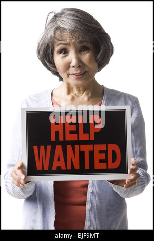 senior woman holding help wanted sign Stock Photo - Alamy