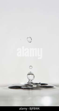 High speed photograph of a water droplet bouncing off a flat water ...