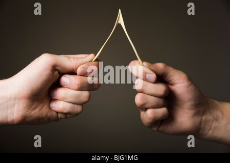 two hands breaking a wishbone Stock Photo - Alamy