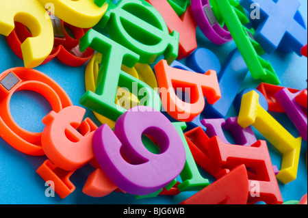 Colorful plastic numbers and letters as frame on a wooden background ...