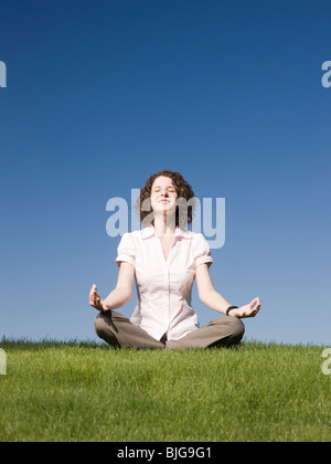 Young businesswoman meditating on the white Stock Photo - Alamy