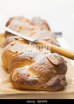 Baking paper with bread and knife on white wooden background Stock ...