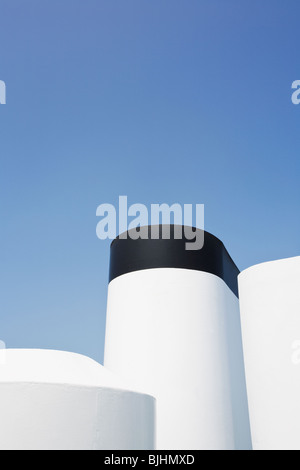 A vertical view of white smoke stacks on the backgrounds of trees Stock ...
