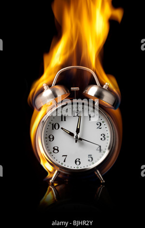 Alarm clock is burning with fire flames Stock Photo - Alamy