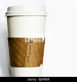 Disposable recycled paper cup with coffee on a wooden table on a sunny ...