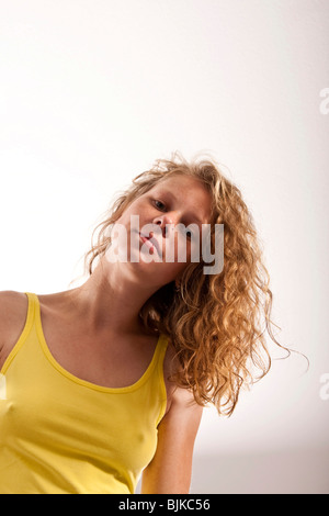 From below young female with curly hair in casual clothes smiling and ...