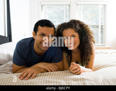 Portrait of a couple snuggling in bed Stock Photo - Alamy
