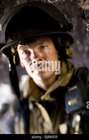 Side view of male Caucasian firefighter teaching schoolkids about fire ...