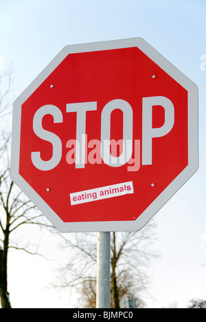 Road sign, Stop sign with sticker „eating animals“, sky with dark ...