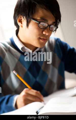 Male Chinese College Student Focusing in Library Studying Stock Photo ...