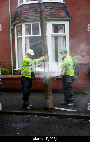 Council worker cutting down a concrete lamp post Stock Photo - Alamy