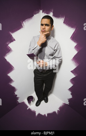 thoughtful man standing in the corner Stock Photo - Alamy