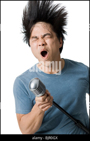 Man rocking out with mic stand Stock Photo - Alamy