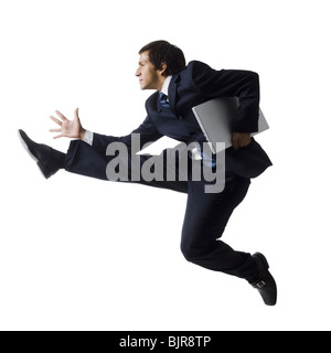 Young businessman jumping with laptop Stock Photo - Alamy
