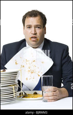 Overweight businessman gorging himself on spaghetti Stock Photo - Alamy