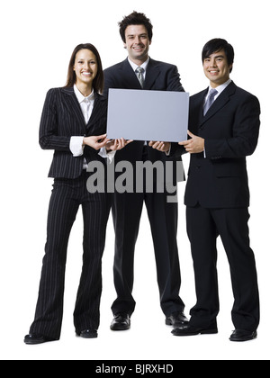 Young business people holding blank sheet of paper on grey background ...