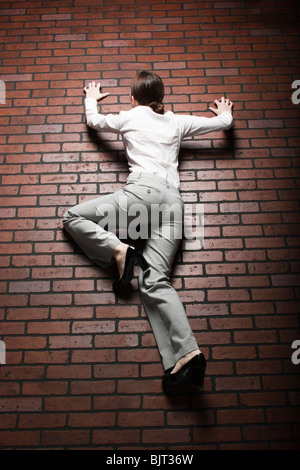 Caucasian woman climbing brick wall outdoors Stock Photo - Alamy