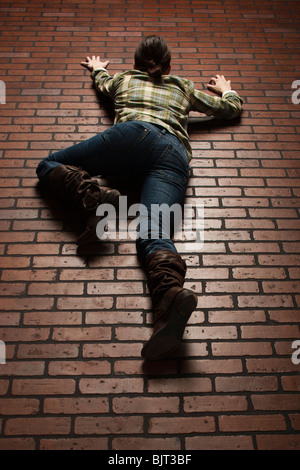 Caucasian woman climbing brick wall outdoors Stock Photo - Alamy