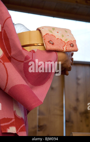 Women wearing yukata holding spa products at a health spa looking out ...