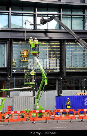 Workmen in a cherry picker platform working on a modern building Stock ...