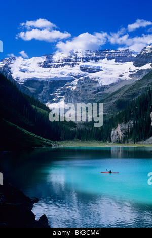 Lake Louise with people kayaking and Victoria Glacier reflection, Banff ...