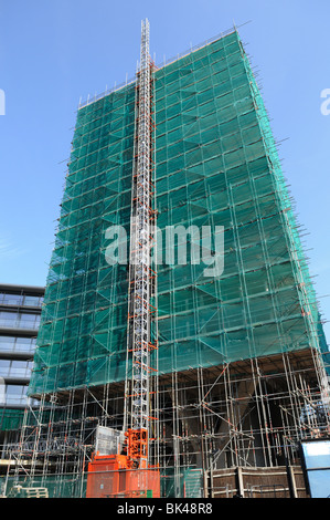 Construction scaffolding surrounds a tall building in a city under ...