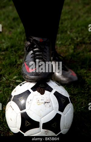 Footballer resting foot on ball Stock Photo - Alamy