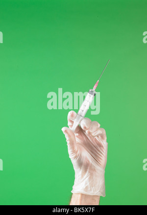 Medical gloved hand with syringe and needles Stock Photo - Alamy