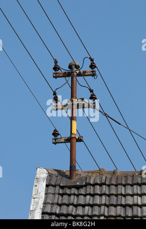 Overhead electrical power lines on a transmission tower against blue ...