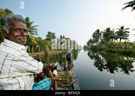 Houseboat captain steering his traditional style kettuvallam boat in ...