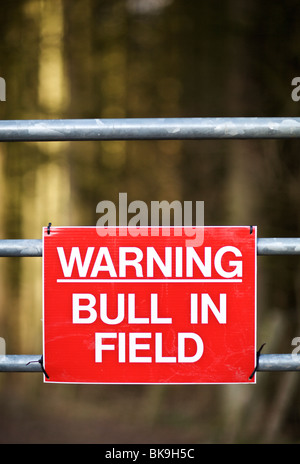 red "warning bull in field" sign on farm gate Stock Photo - Alamy