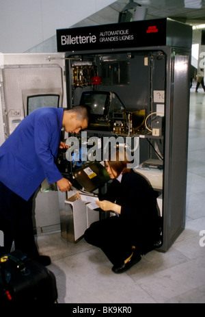Technician repairing broken ticket machine inside station on the ...