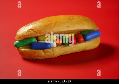 Candy sandwich sweet metaphor over red background Stock Photo - Alamy