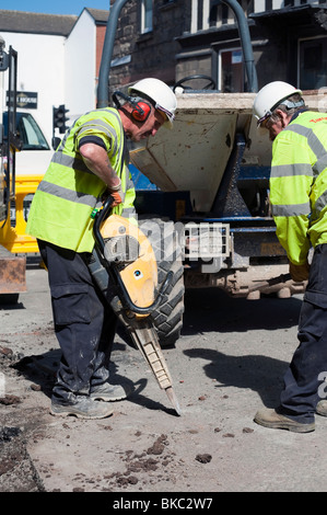 Workman digging up the road Stock Photo - Alamy