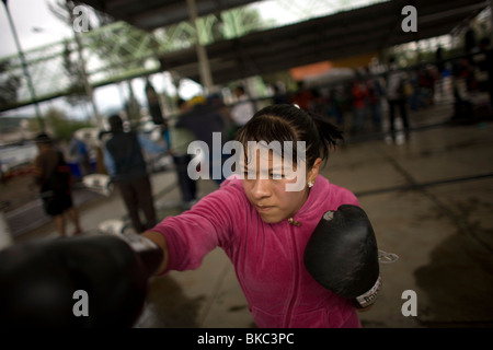 Teenager in boxing gloves trains and exercises with adult trainer on ...