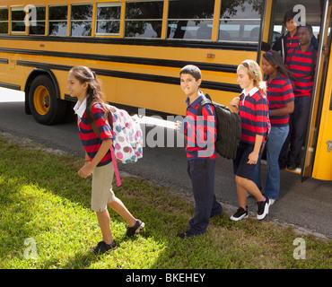 Young children getting off an American school bus in Manhattan NYC ...