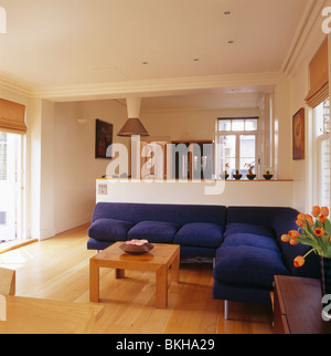Blue sofa and a pale wood coffee table in a blue living room painted in ...