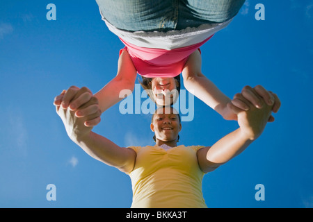 Two young girls putting their heads together for a portrait against a ...