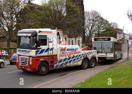 Tow truck about to tow away a broken down bus Stock Photo - Alamy