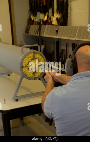 Forensic expert fire handgun into Kevlar bullet trap. Bullets fired ...