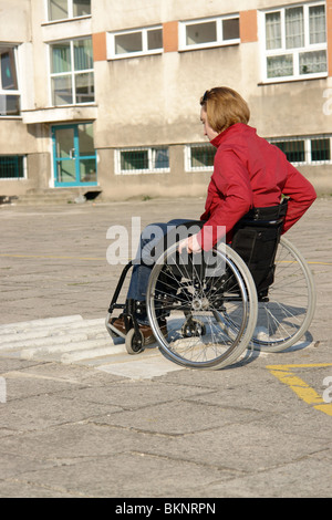 Handicapped woman practicing wheelchair riding over obstacle course ...