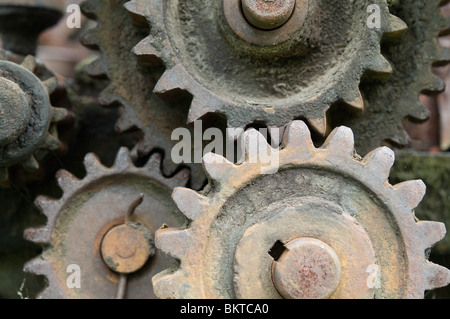 Antique cogs and gears lie exposed to the elements on an antique piece ...