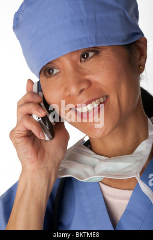 Asian woman medical professional talking phone while reading document ...